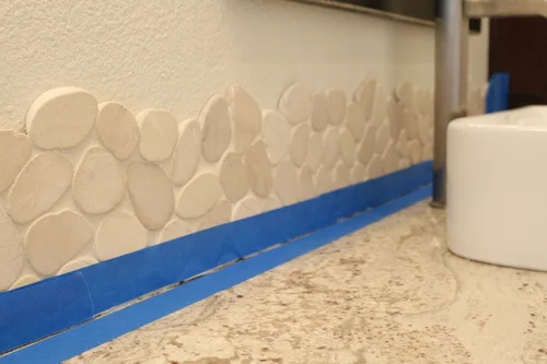 Grouting the live edge pebble tile backsplash.... — Beckwith's Treasures