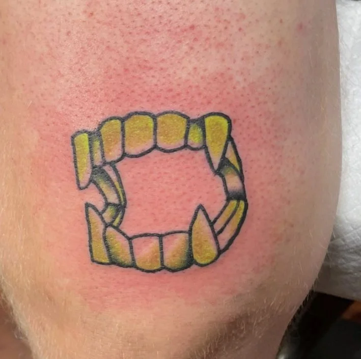 Plastic Vampire Teeth Tattoo