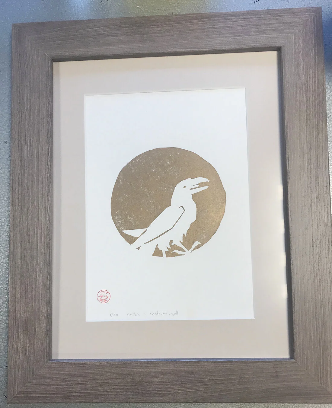 Kråka i sentrum trykket i gull på hvitt papir, innrammet — Drømmeverkstedet