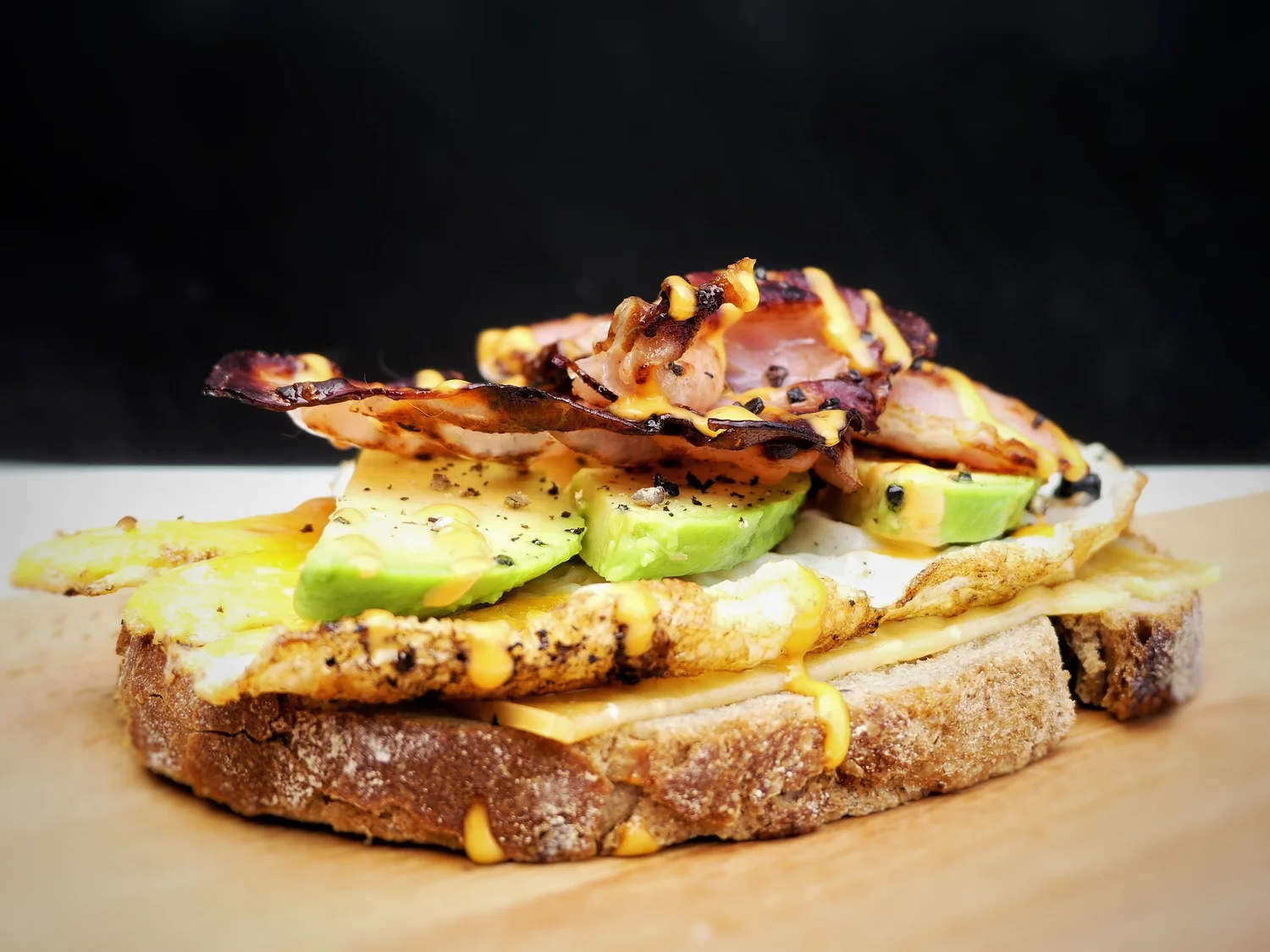 Oerbrood, gesmolten oude kaas, gebakken ei, avocado & bacon ...