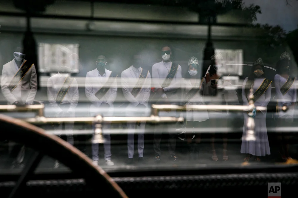Funeral delayed: tiaras, white outfits, turquoise face masks — AP Photos