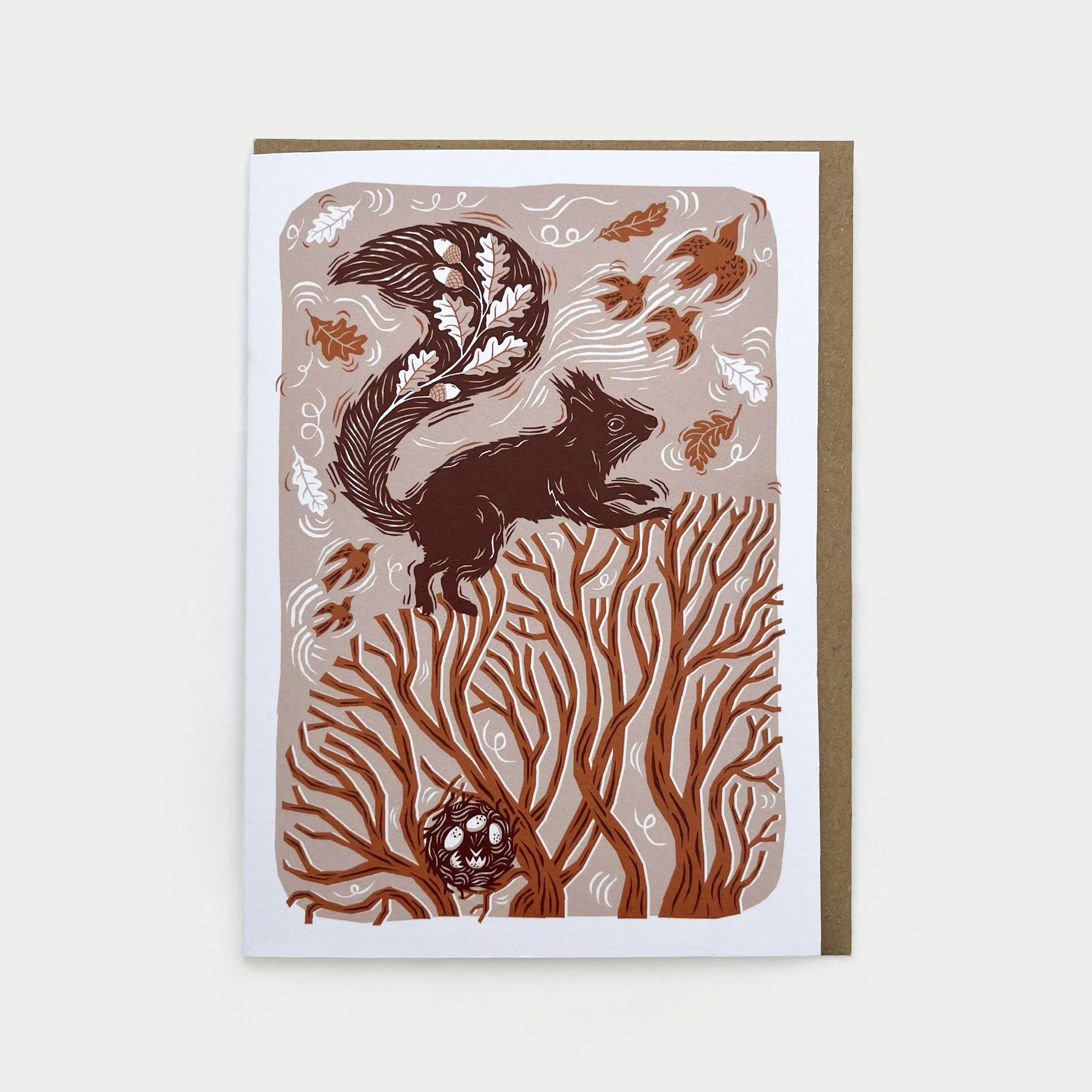 A seasonal greetings card featuring a squirrel playing amongst the tree ...