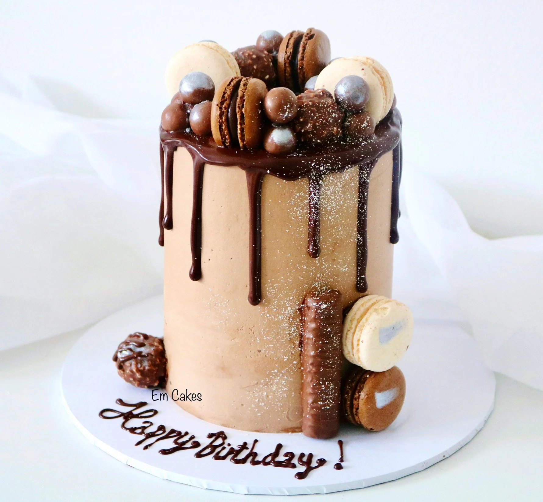 chocolate drip and macarons cake | Em Cakes