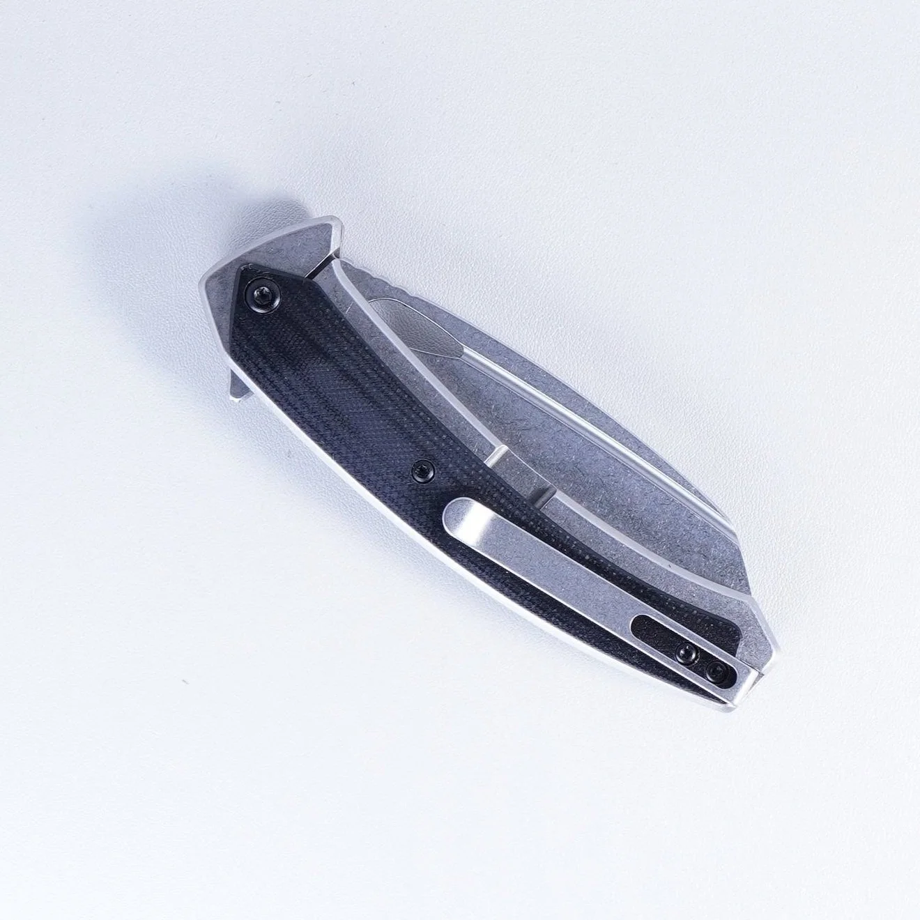 Ginunting style folding knife providing a downward blade angle without ...