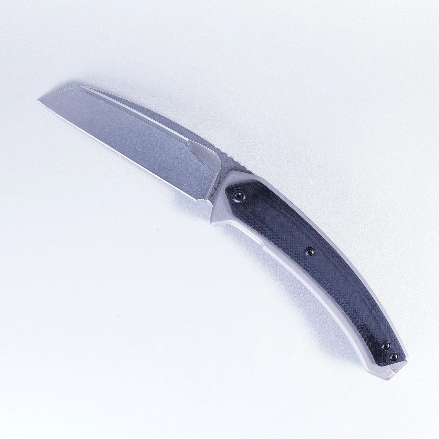 Ginunting style folding knife providing a downward blade angle without ...