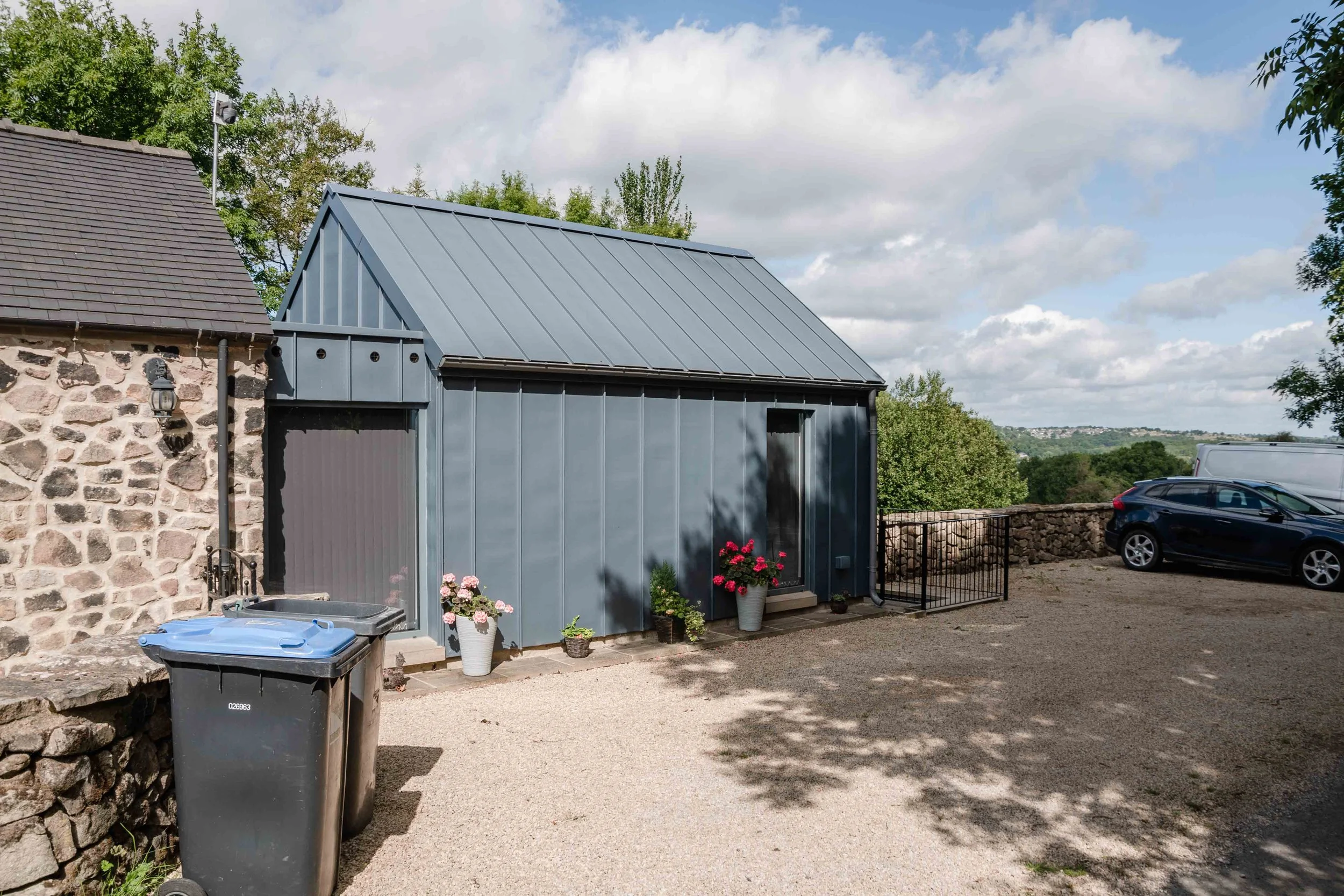 Contrasting zinc clad extension to historic agricultural barn with flat ...