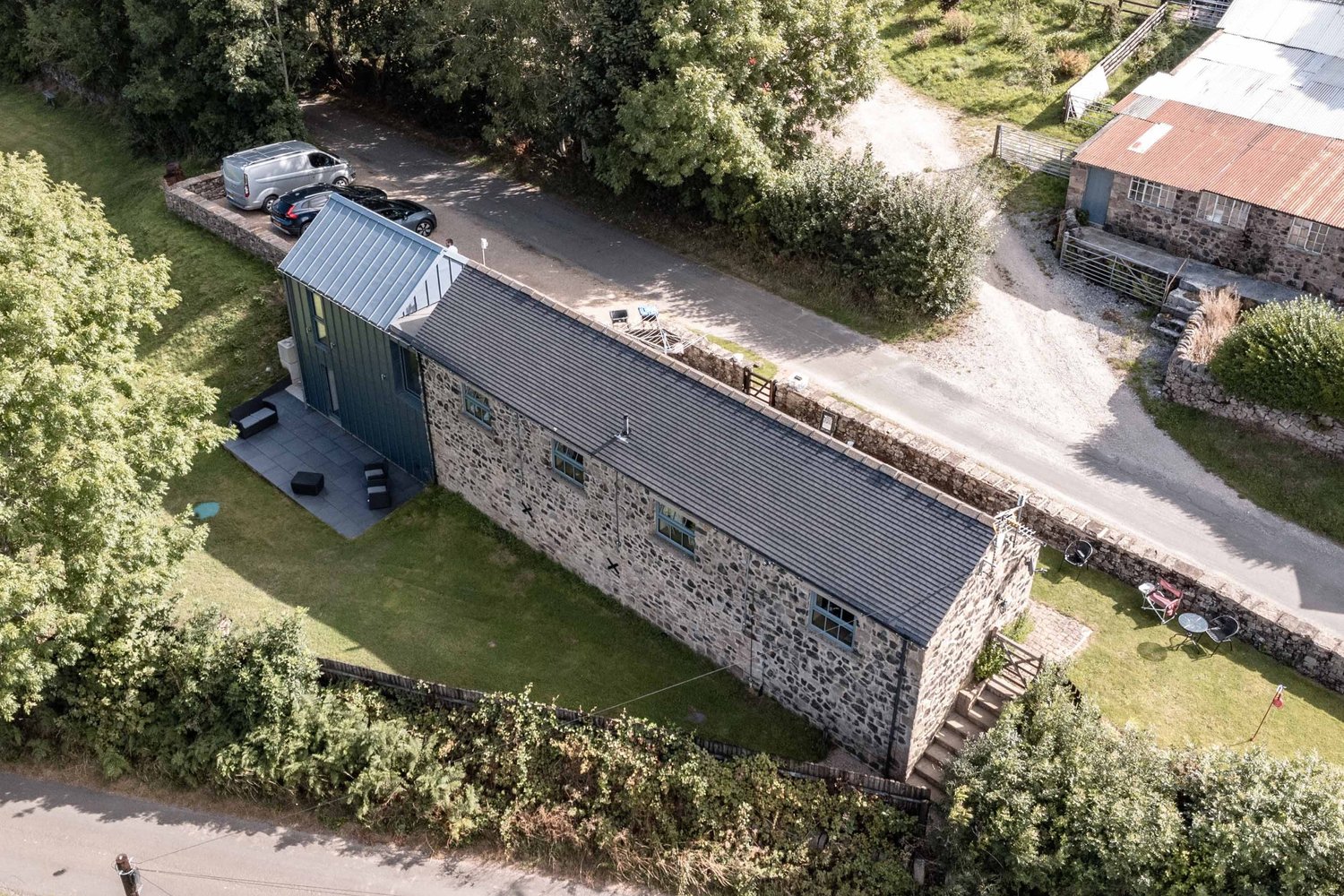 Contrasting zinc clad extension to historic agricultural barn with flat ...