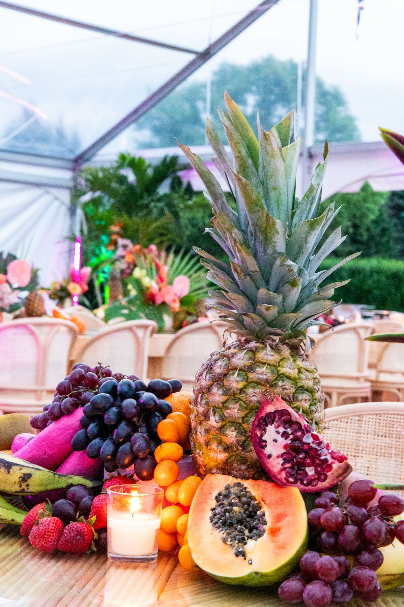 A Palm Royale party with palms, floral and fruit arrangements and a ...