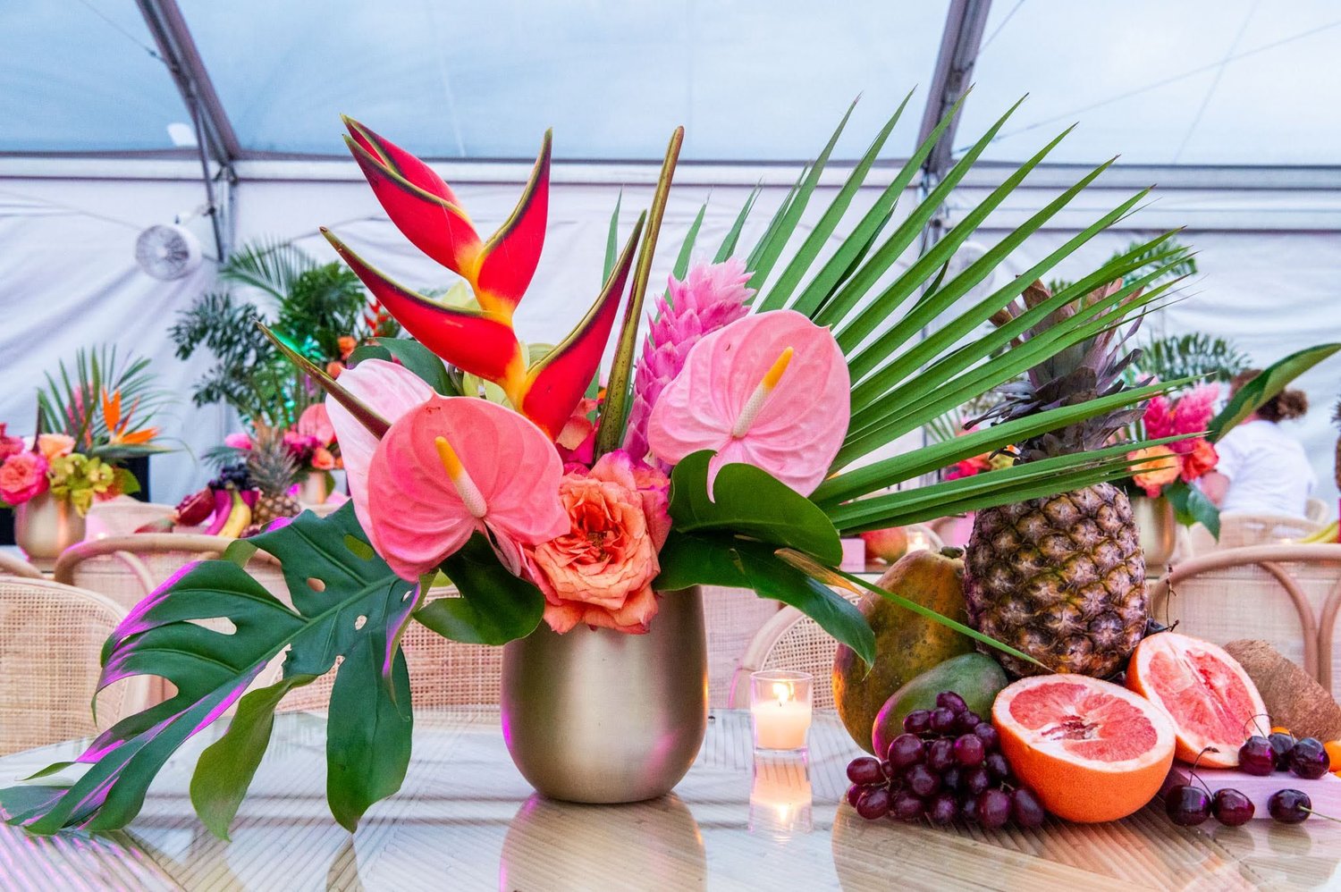 A Palm Royale party with palms, floral and fruit arrangements and a ...
