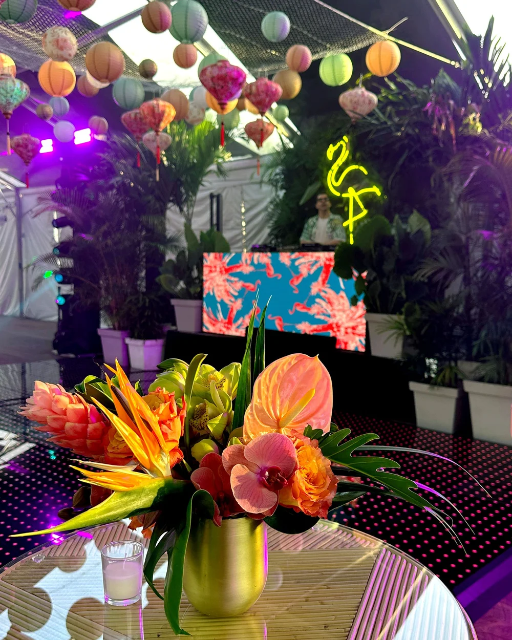 A Palm Royale party with palms, floral and fruit arrangements and a ...