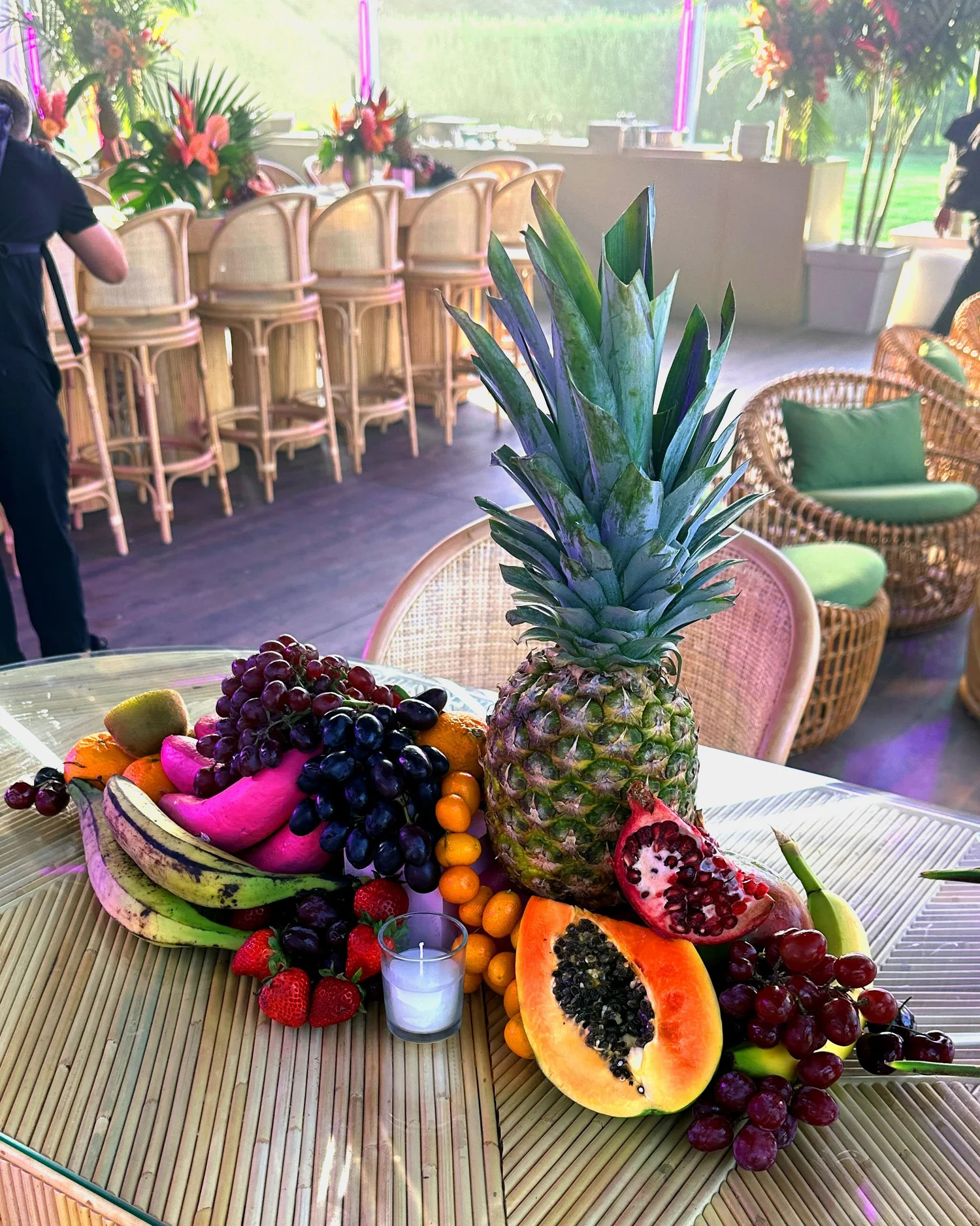 A Palm Royale party with palms, floral and fruit arrangements and a ...