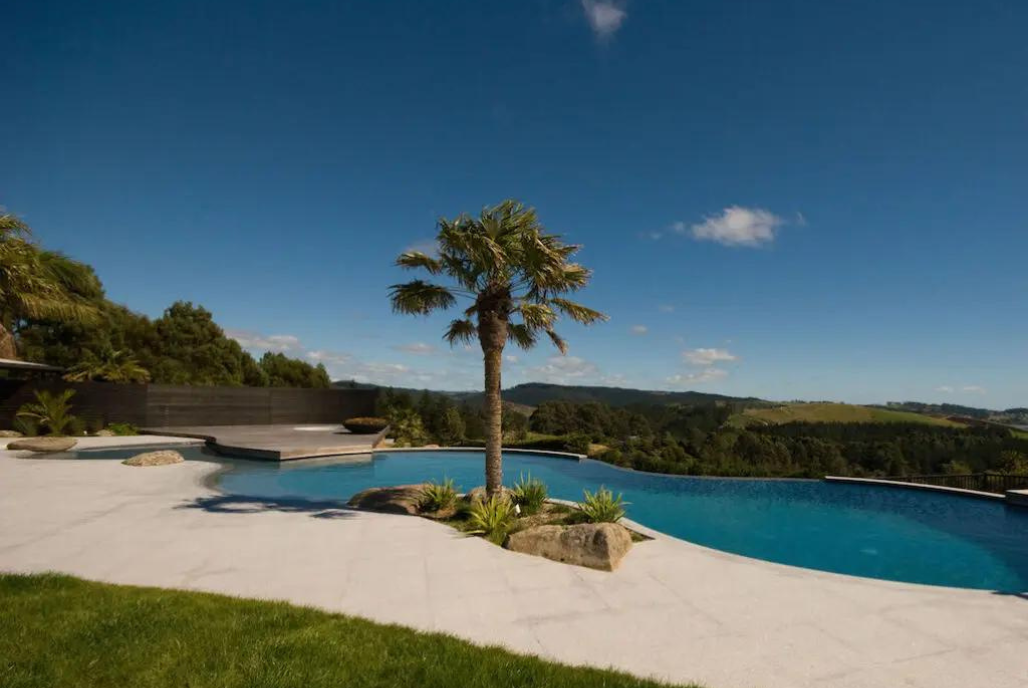 Curved infinity edge pool flows with nature — Mayfair Pools NZ - Your ...