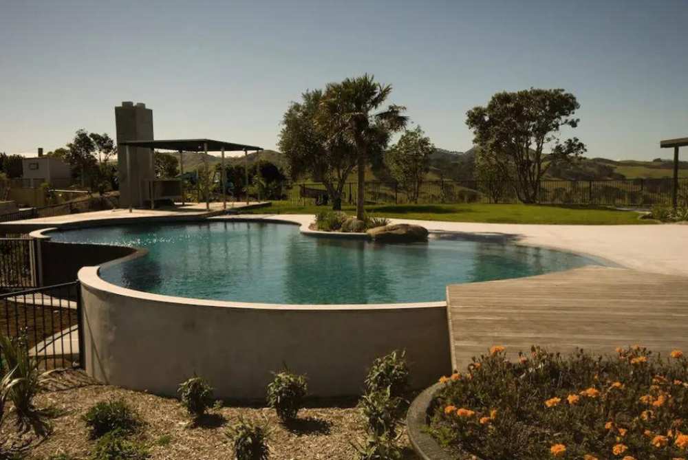 Curved infinity edge pool flows with nature — Mayfair Pools NZ - Your ...