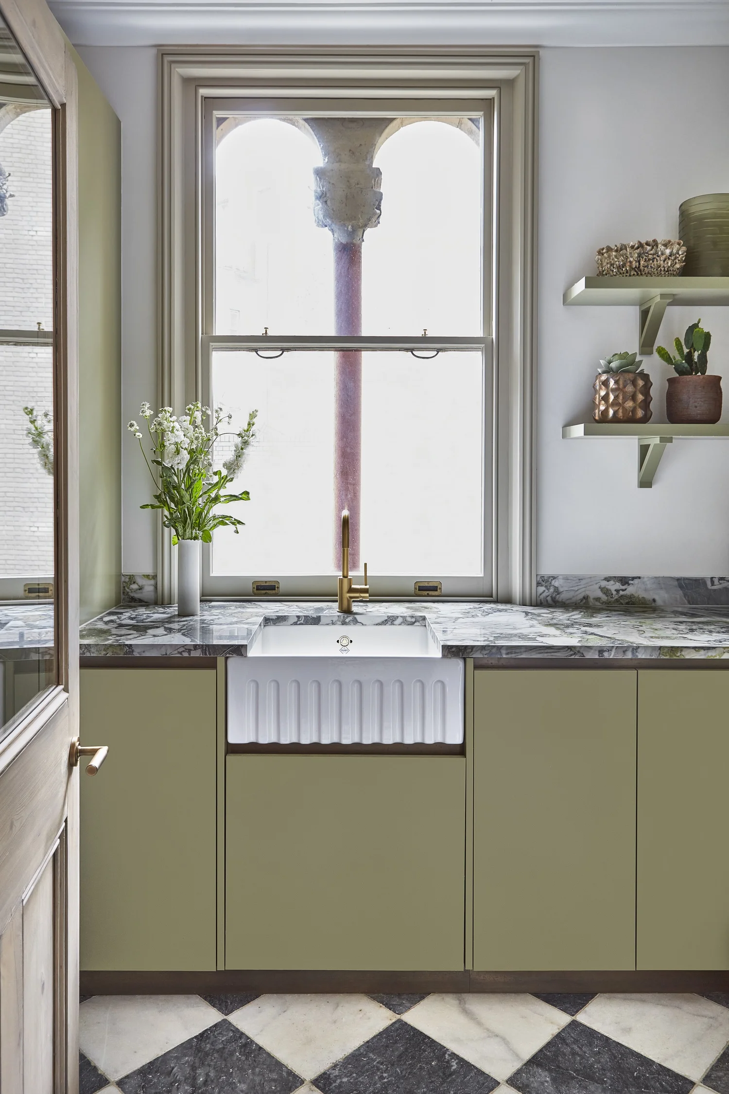 A luxury green and white timber kitchen and utility room with a ...