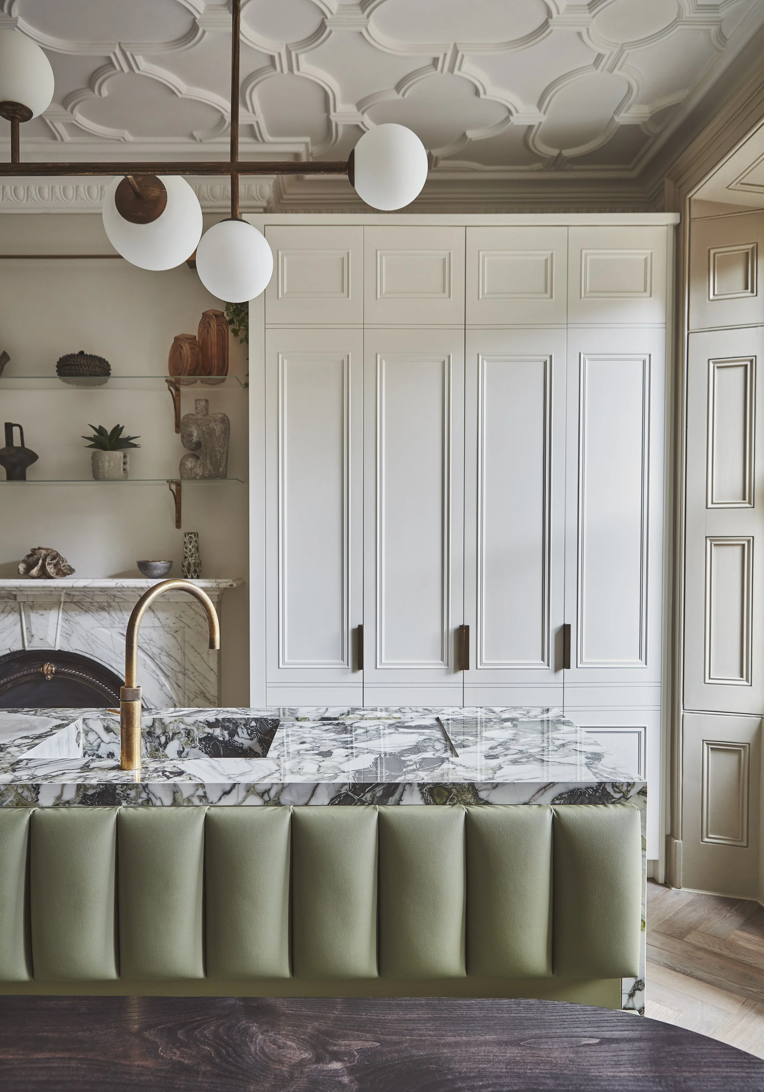 A luxury green and white timber kitchen and utility room with a ...